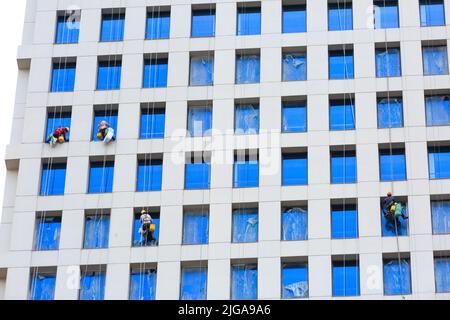 group of window washers hanging on ropes on a skyscraper facade Stock ...