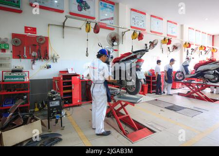 Professional motorcycle repairman at a service center of Honda ...
