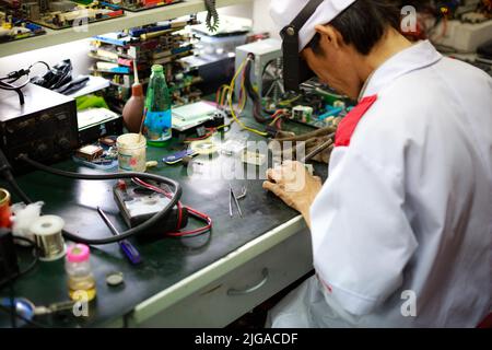 technicians are checking a customer's computer for repair at a computer ...