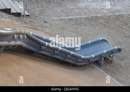 A closeup of gray slide seen on sandy playground Stock Photo - Alamy