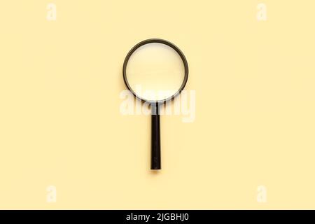 Magnifying glass on beige background Stock Photo - Alamy