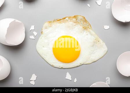 Composition with tasty fried egg and shells on light background Stock ...