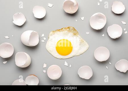 Composition with tasty fried egg and shells on light background Stock ...