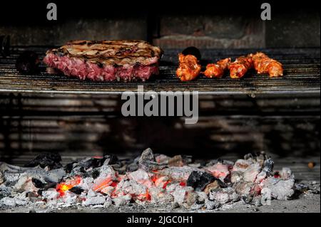 Pork skewers cooking over charcoal on a barbecue Stock Photo - Alamy