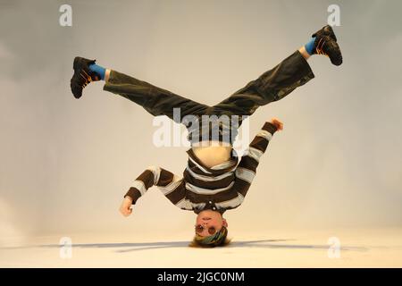 boy in breakdance position, difficult dance position, stands on one ...