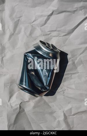 crumpled paper with hand shadow and crumbled crushed aluminum can ...