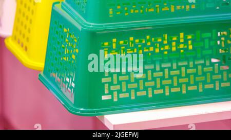 Pyramid of green and yellow plastic baskets. Stack of colorful ...