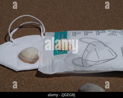 FFP2 face mask on a sandy beach Stock Photo - Alamy