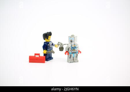 Man help to wind up the clockwork robot Stock Photo - Alamy