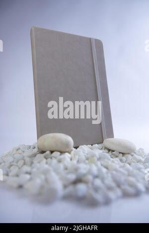 Grey notebook on a mountain stack of white rocks. Beautiful studio ...