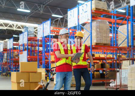 Warehouse manager talking with logistics employee in warehouse ...