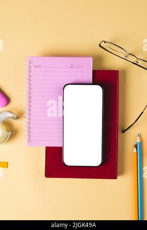 Composition of smartphone with copy space and school equipment on pink ...