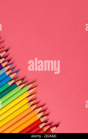 Vertical composition of colorful crayons on blue surface with copy ...