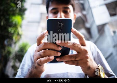 A boy looking at his phone. Dhaka, Bangladesh Stock Photo - Alamy