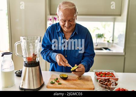 Senior man smiling confident cutting datil at kitchen Stock Photo - Alamy
