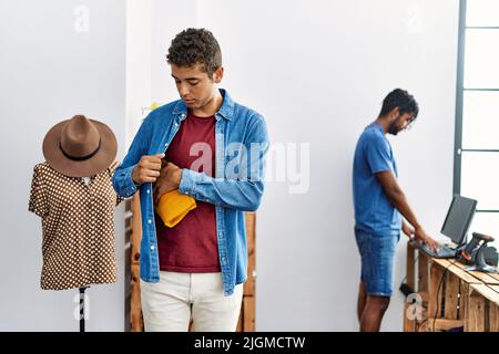 Two men shopkeeper and customer thief stealing clothes at clothing ...