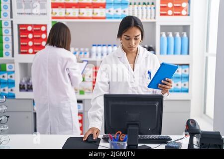 Two women pharmacist using touchpad holding pills at pharmacy Stock ...