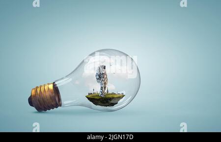 Spaceman inside light bulb . Mixed media Stock Photo - Alamy