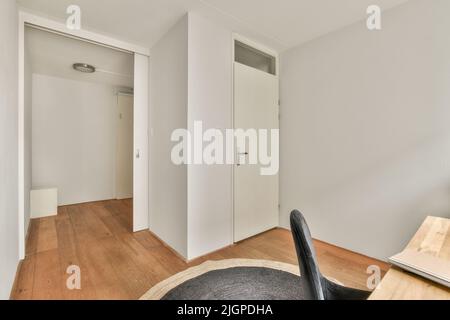 Comfortable chair placed near desk with computer monitors and ...