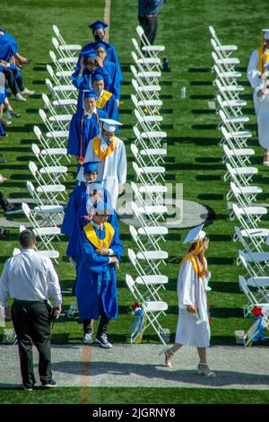 Wearing their ceremonial caps and gowns, multiracial high school ...