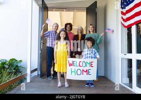 Multiracial multigeneration family with welcome home text and flags of ...