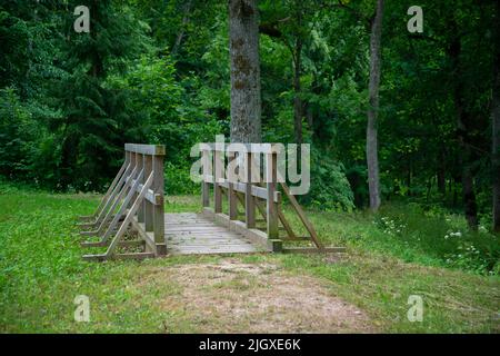 A wooden pedestrian footbridge leads to autumn colors and fall foliage ...