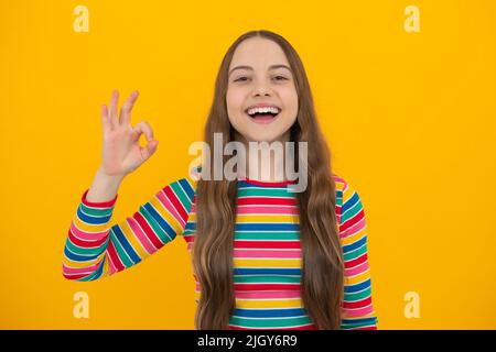 Portrait of teen girl making ok gesture, isolated background. Young ...
