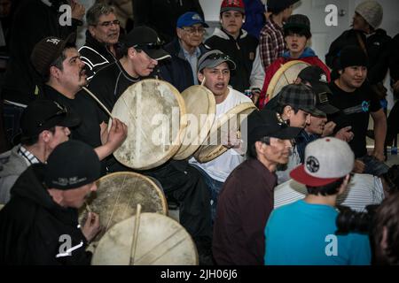 Indigenous Dene men playing drums and traditional handgames in the ...