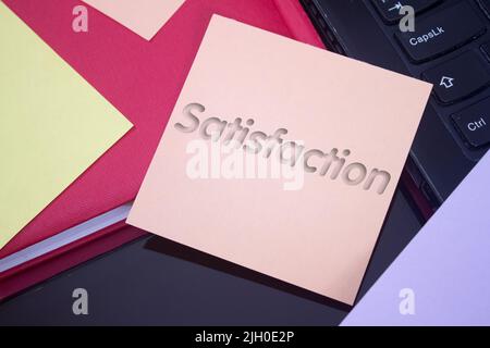 Satisfaction. Text on adhesive note paper. Event, celebration reminder ...
