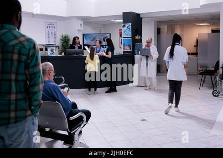 Busy hospital reception desk with diverse people in waiting room, asian ...