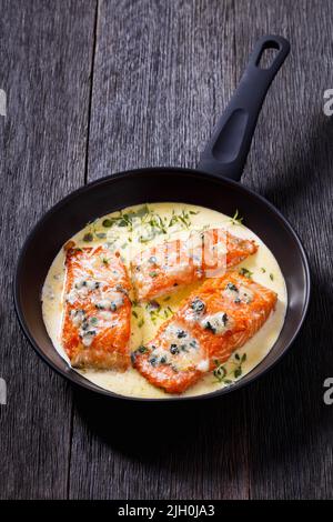 salmon fillet with creamy blue mold cheese sauce and mushrooms on white ...