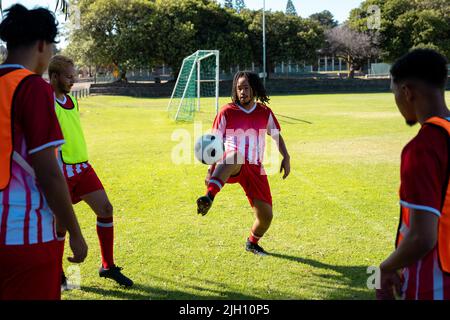 The male soccer players on a grassy field, with one in a kicking ...