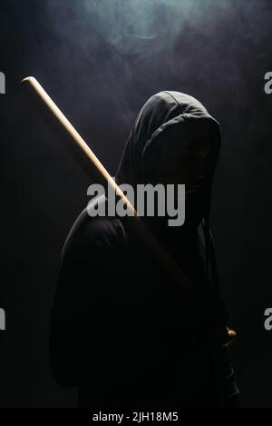 Criminal or bandit holding a baseball bat Stock Photo - Alamy