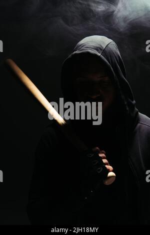 African american bandit in hood holding baseball bat on black ...