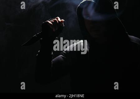 Silhouette of african american bandit in hood and glove holding ...