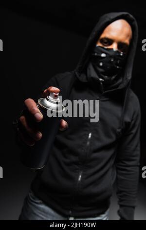 African american hooligan with mask on face holding baseball bat in ...