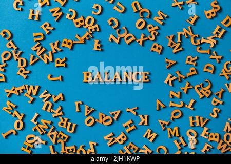 Word BALANCE made out of wooden letters on bright blue background ...