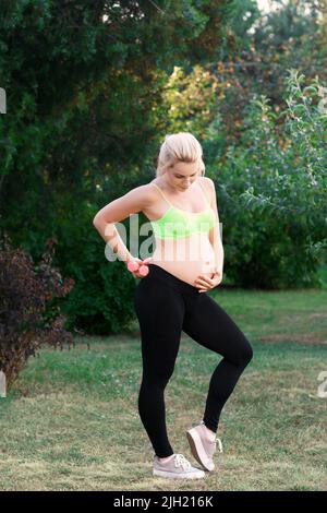 Fitness pregnant woman feeling her baby push Stock Photo - Alamy