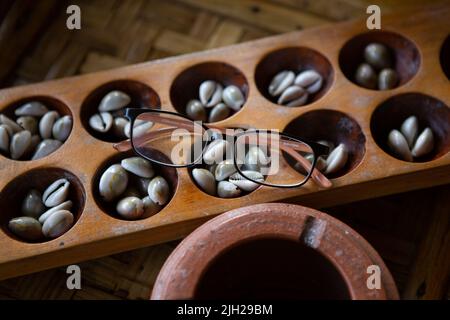 Congklak, a traditional game that uses a wooden board with 14 to 16 ...