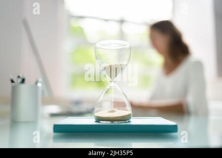 Business woman running with an hourglass. Deadline Stock Photo - Alamy