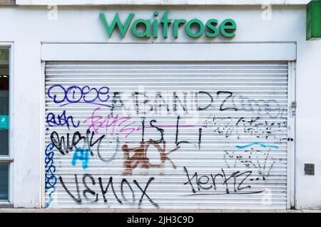 Close store shutter vandalised with graffiti Stock Photo - Alamy