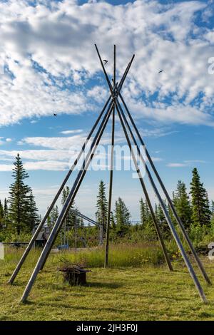 Wooden poles of traditional teepee at cabin in summer, near the ...