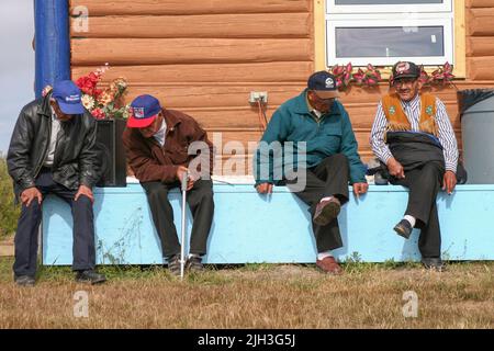 Indigenous Dene elder men sitting outside Prophet Ayah's house on a ...