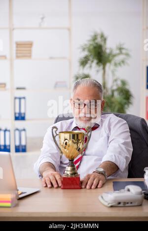 Old businessman employee being awarded with golden cup Stock Photo - Alamy