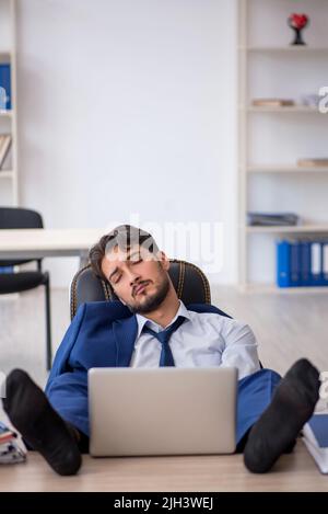 Young businessman employee extremely tired at workplace Stock Photo - Alamy