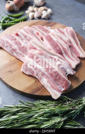Raw fed bacon strips on chopping board Stock Photo - Alamy