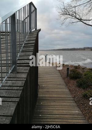 A wooden pier leads to a viewing platform. Wooden site in front of the ...