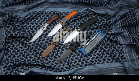 Various pocket knives with retractable blades. Light fabric background ...