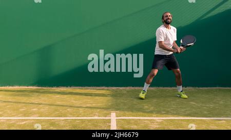 A caucasian padel player jump to the ball, good looking for posts and ...