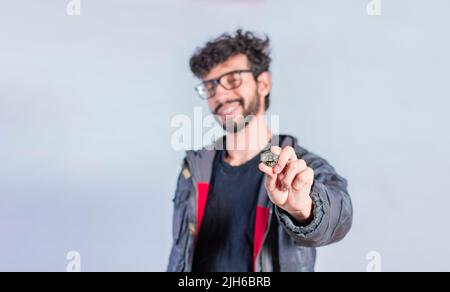 Young hispanic man holding bitcoin virtual money at retail shop smiling ...